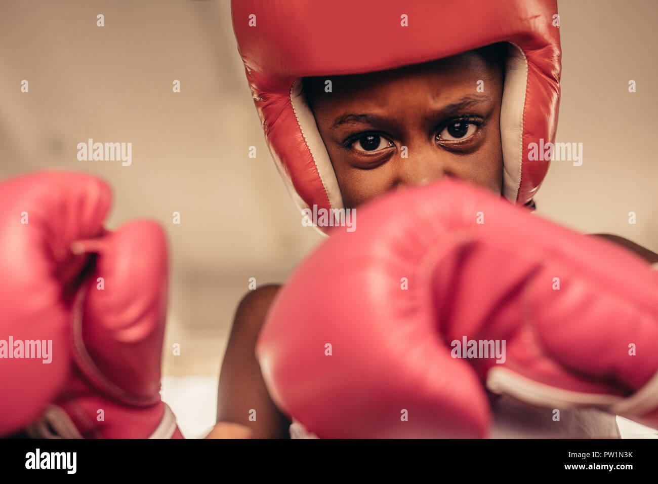 Kid in boxing gear during a boxing fight. Close up of a determined ...