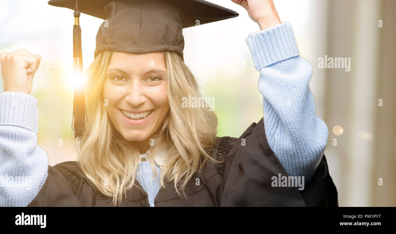 Young graduate woman happy and excited celebrating victory expressing ...