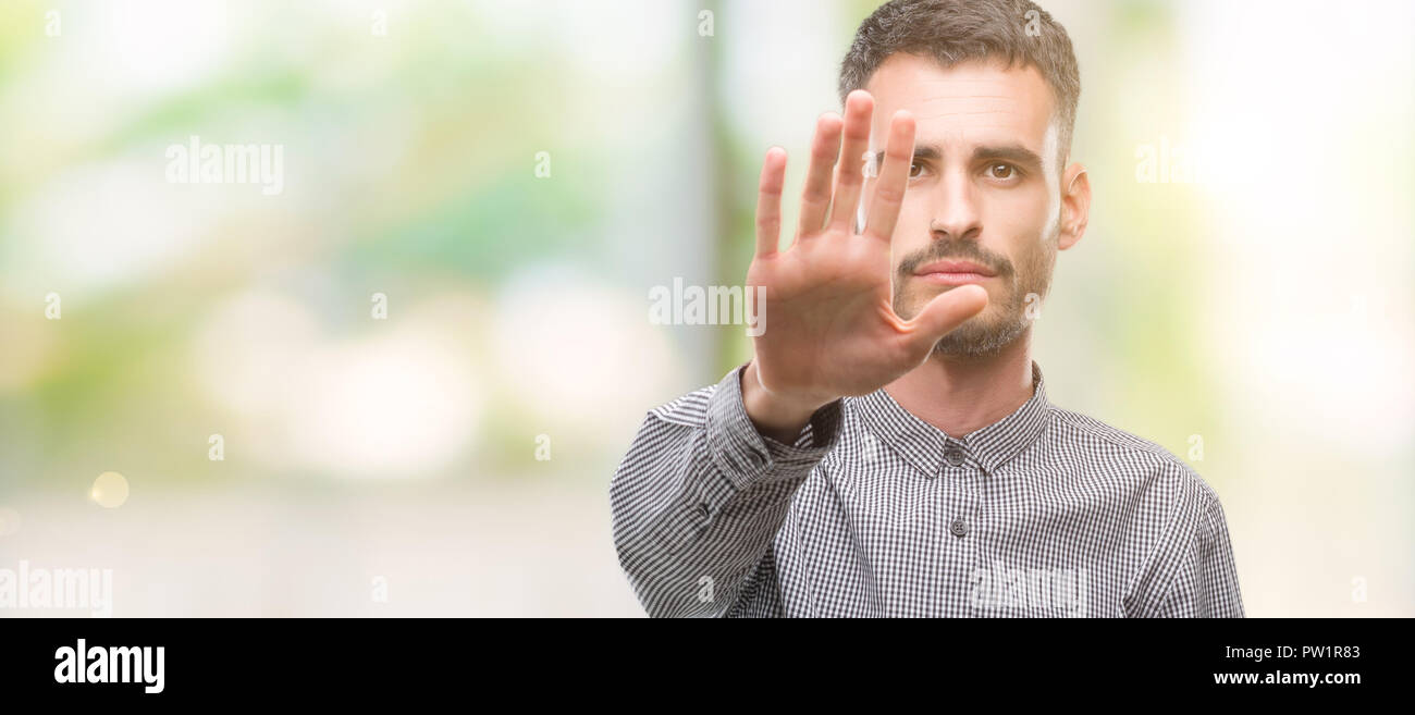 Young hipster man doing stop sing with palm of the hand. Warning ...