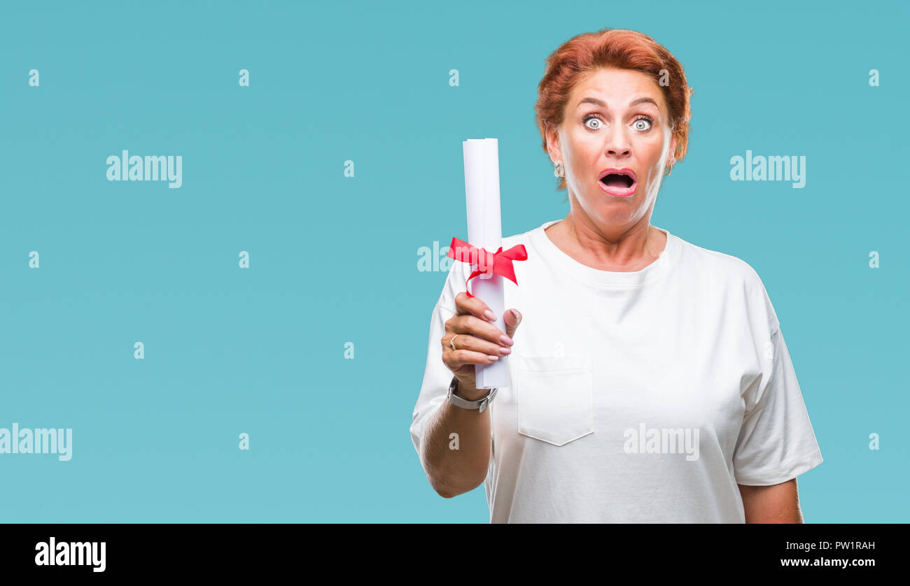 Senior caucasian woman holding degree certificate over isolated ...