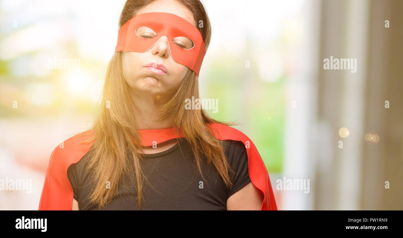 Middle age super hero woman wearing red mask and cape with sleepy ...