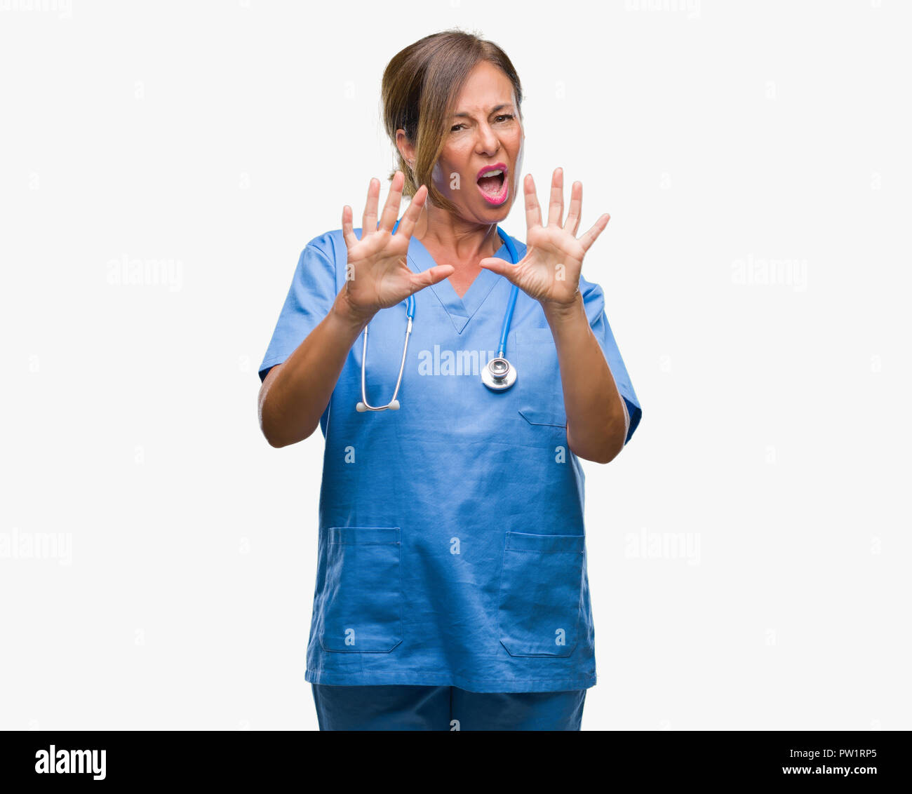 Middle age senior nurse doctor woman over isolated background afraid ...