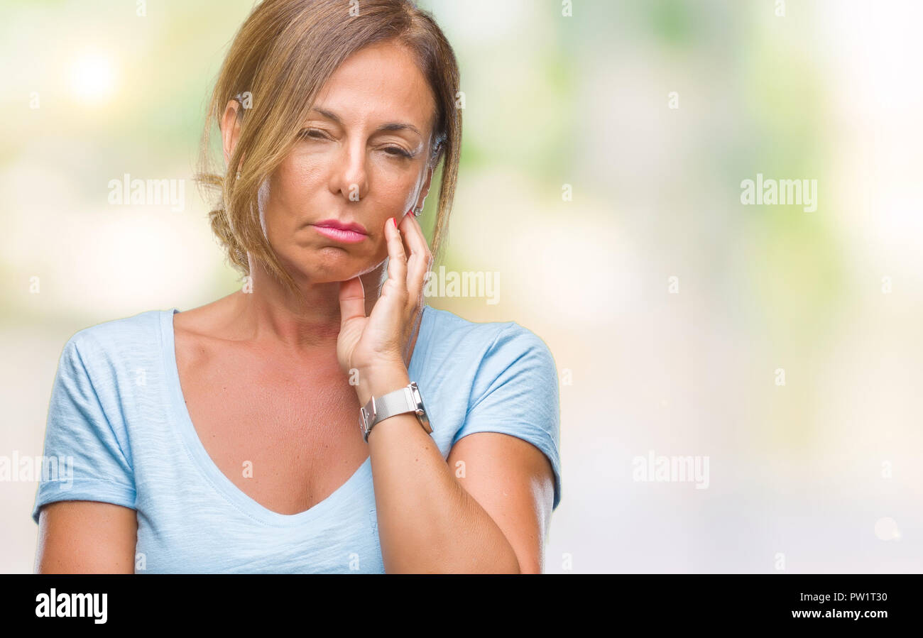 Middle age senior hispanic woman over isolated background thinking ...