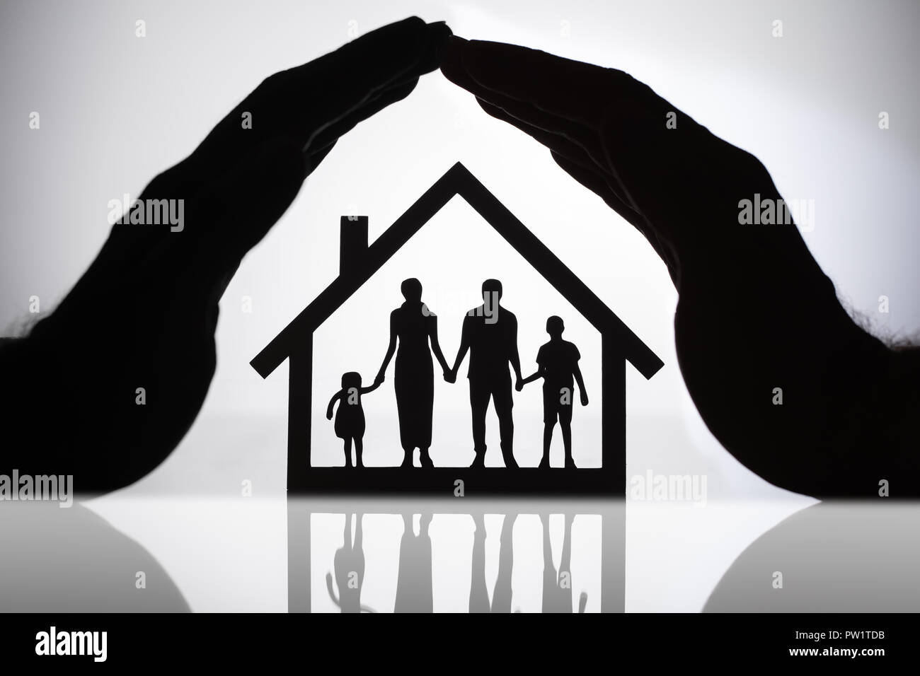 Silhouette Of A Person's Hand Protecting House With Family Figures ...