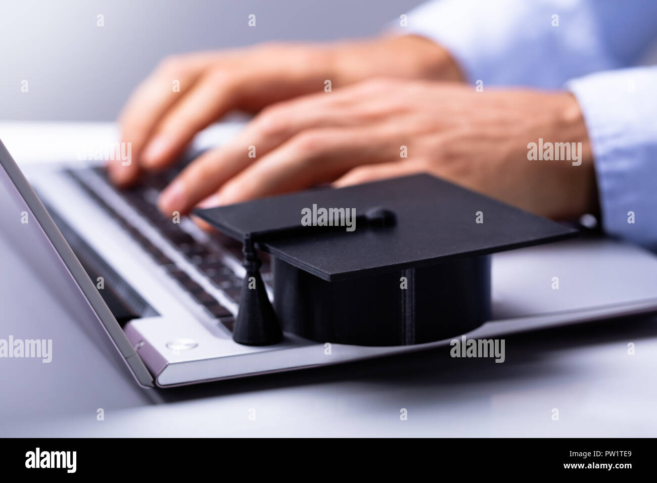 Businessperson Using Laptop With Black Graduation Hat On Keypad Stock ...