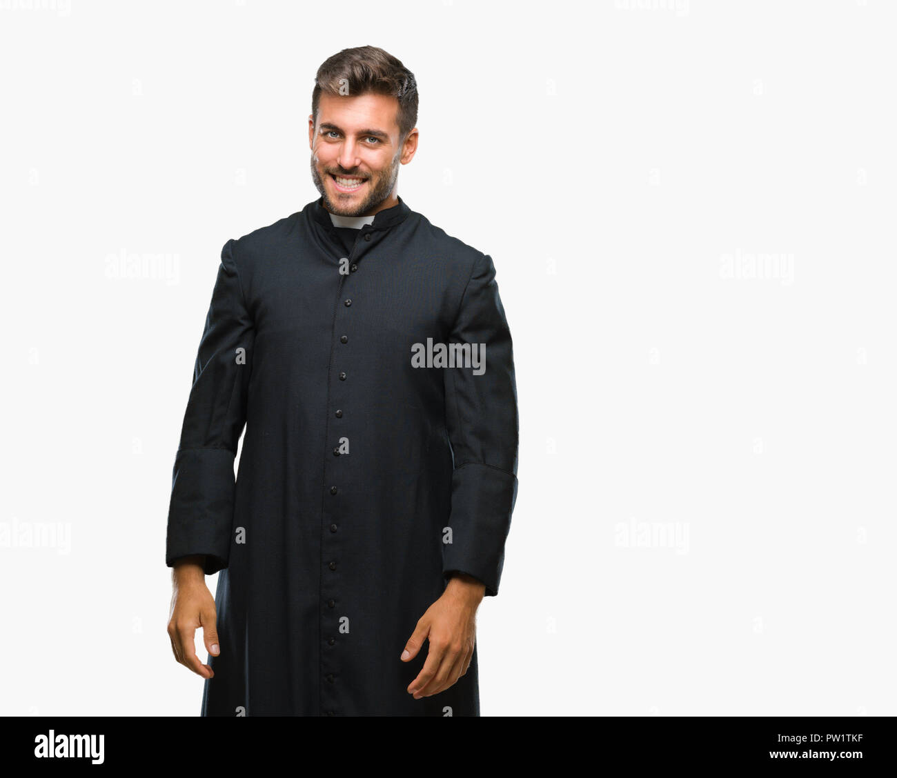 Young catholic christian priest man over isolated background looking ...