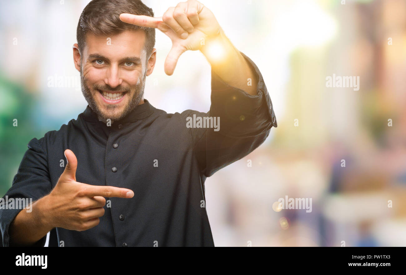 Young catholic christian priest man over isolated background smiling ...
