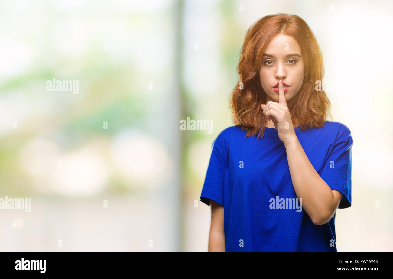 Young beautiful woman over isolated background asking to be quiet with ...