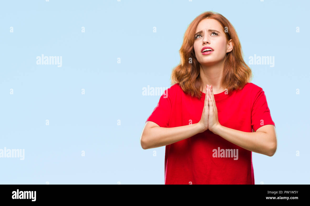 Young beautiful woman over isolated background begging and praying with ...