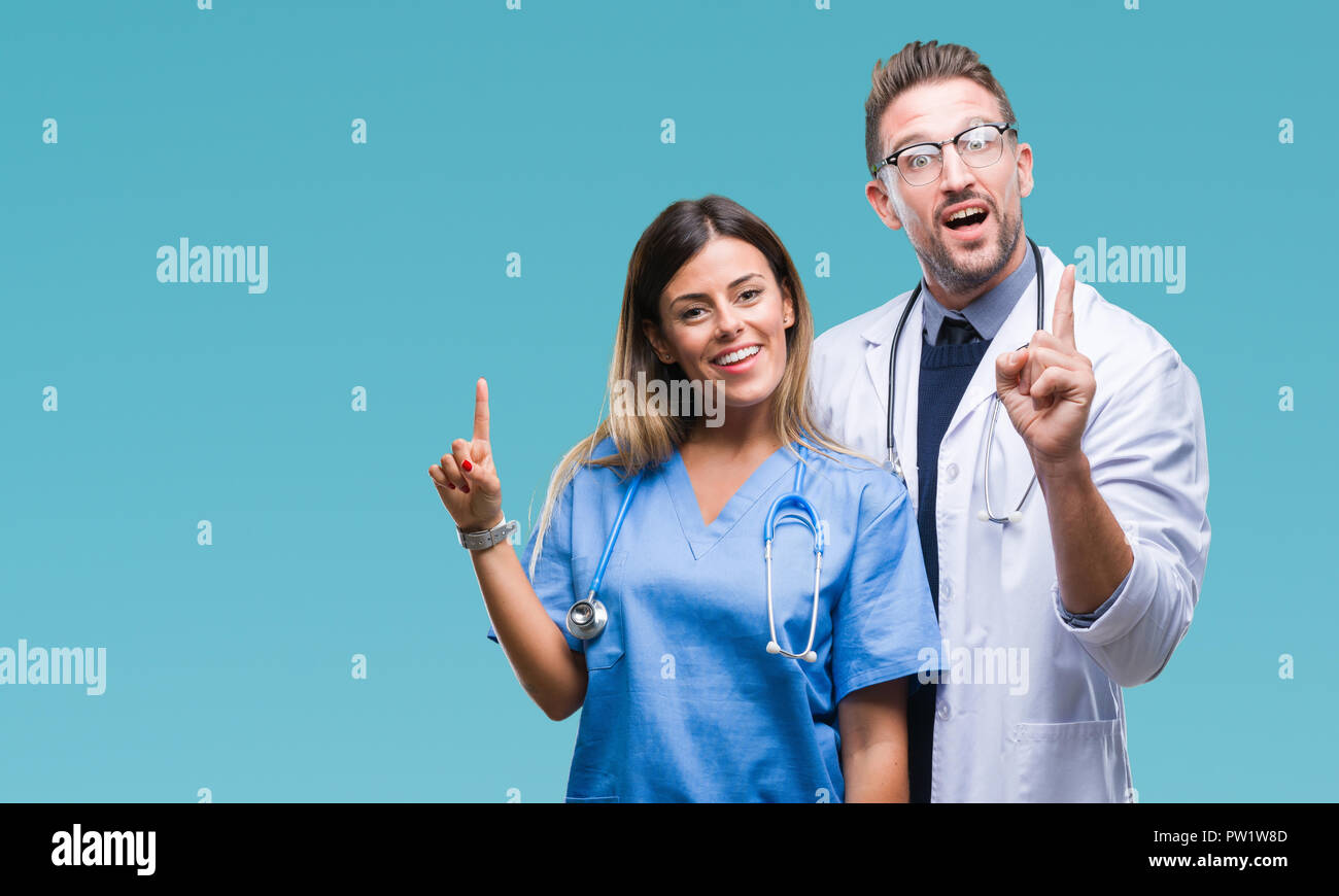 Young couple of doctor and surgeon over isolated background pointing ...