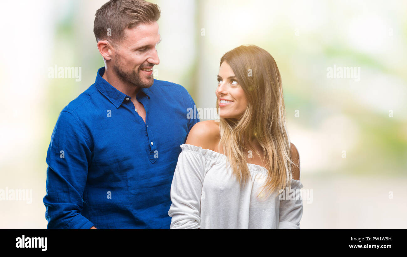 Young couple in love over isolated background looking away to side with ...