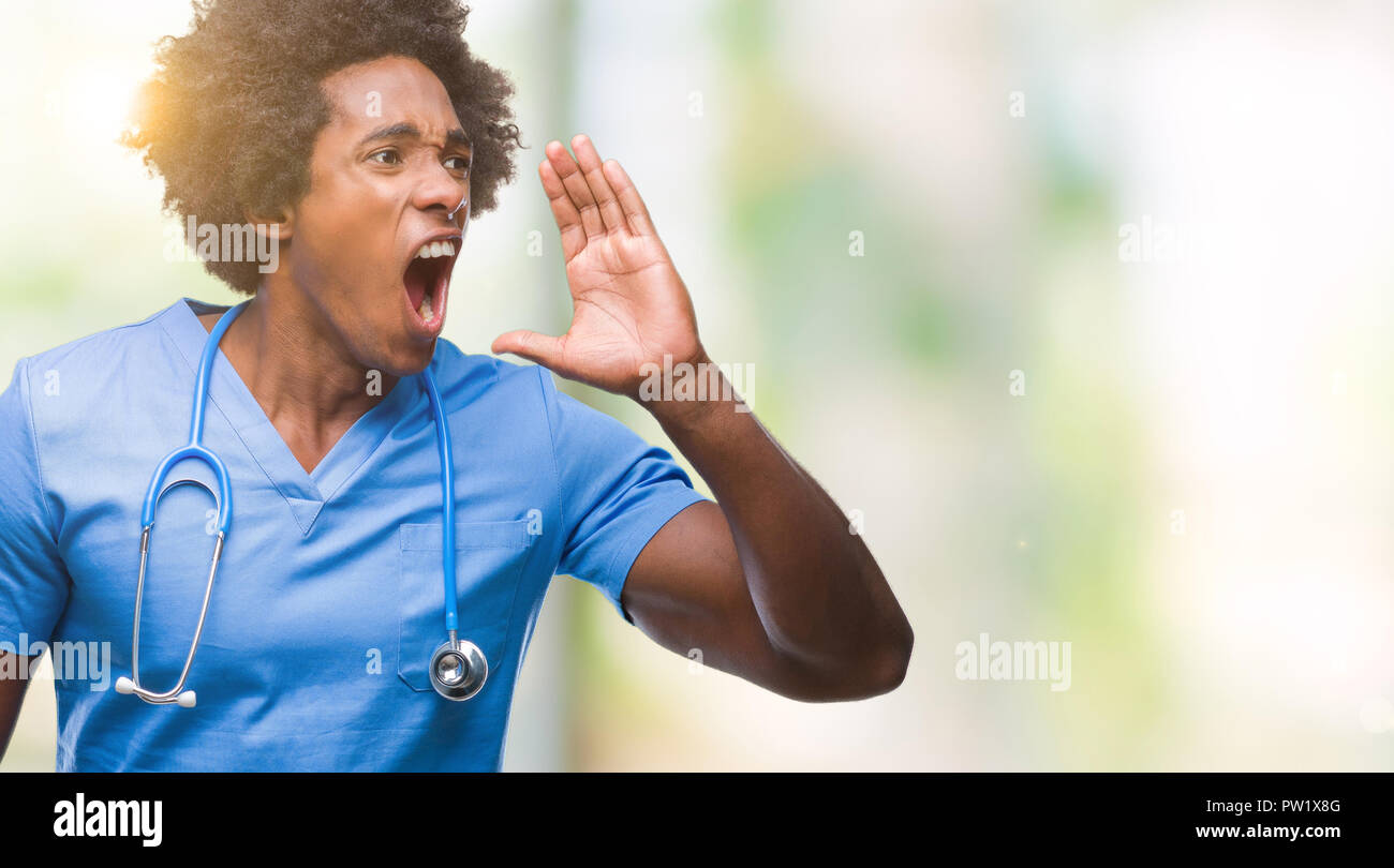 Afro american surgeon doctor man over isolated background shouting and ...