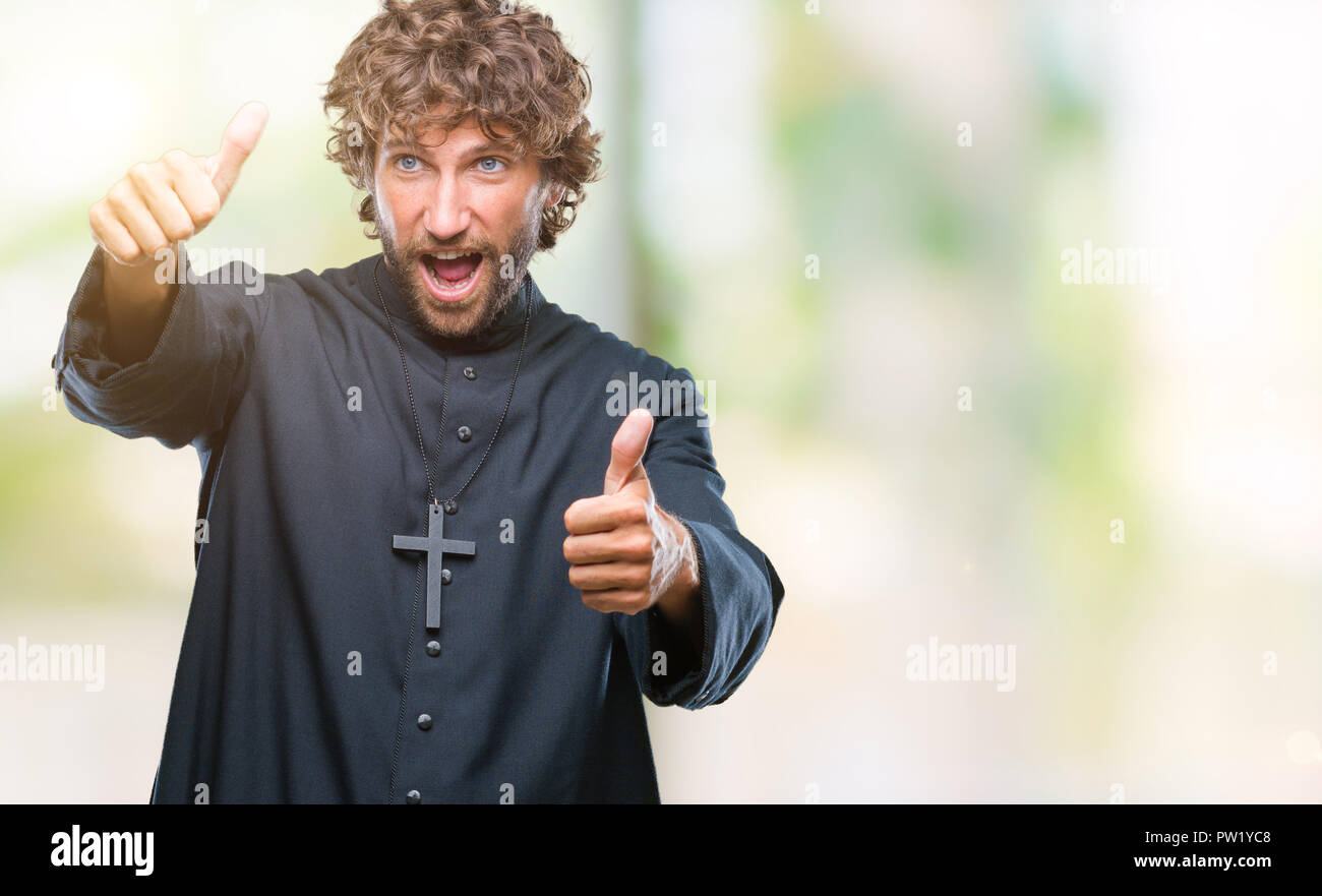 Handsome hispanic catholic priest man over isolated background ...