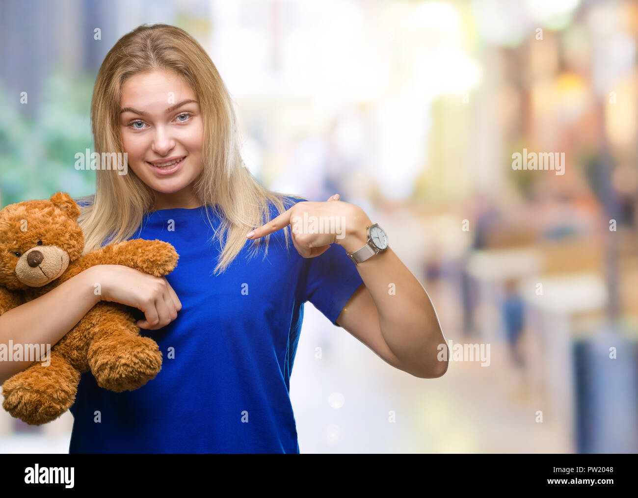 Young caucasian woman holding cute teddy bear over isolated background ...