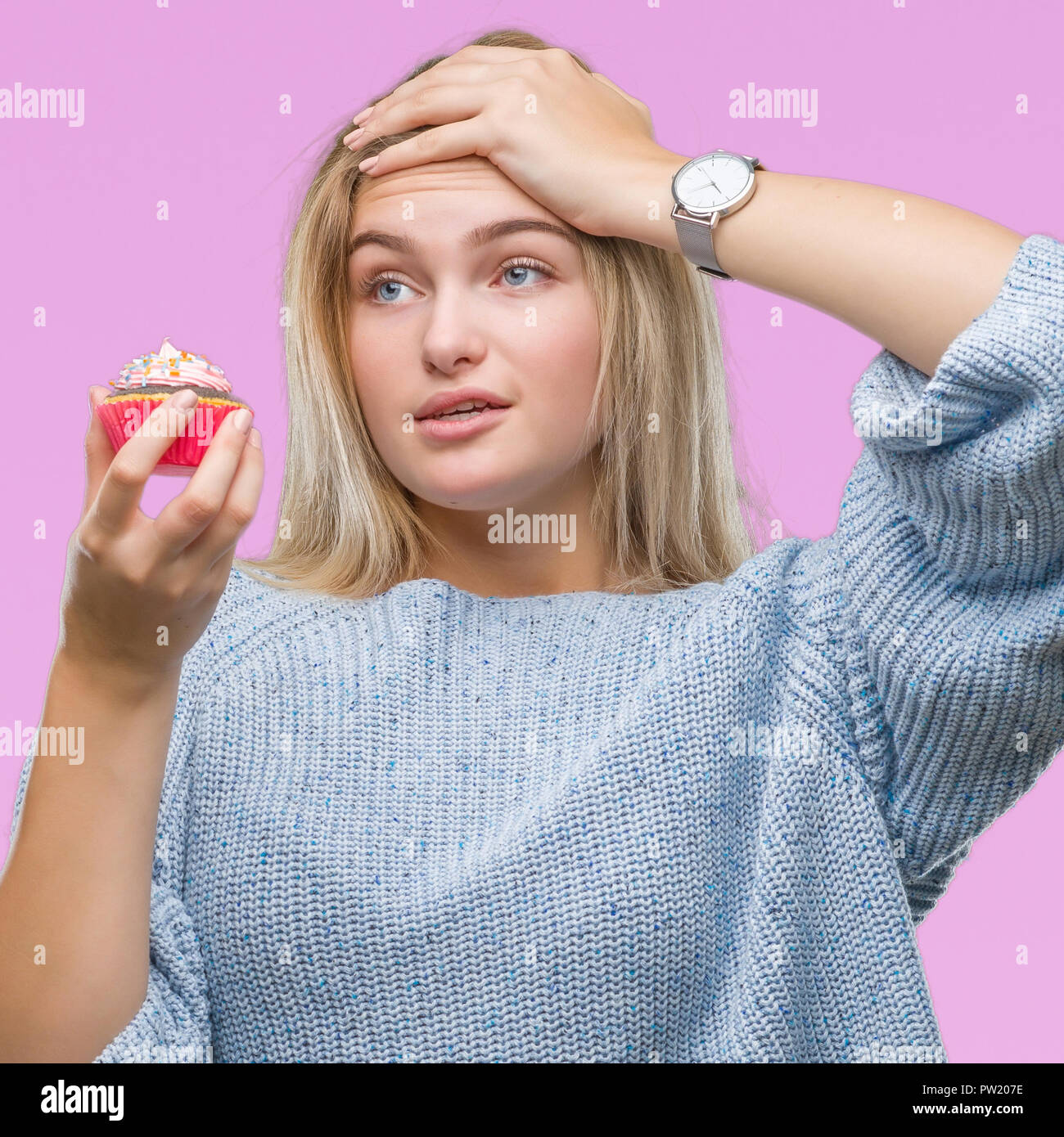 Young caucasian woman eating sweet cupcake over isolated background ...