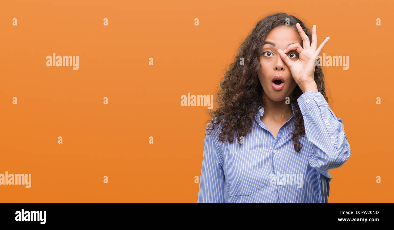 Young hispanic business woman doing ok gesture shocked with surprised ...