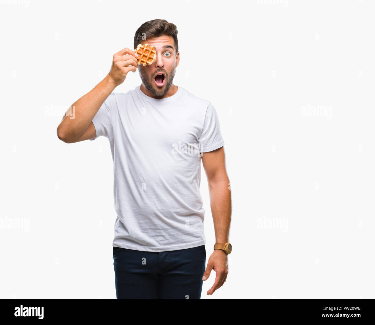 Young handsome man eating a sweet waffle over isolated background ...