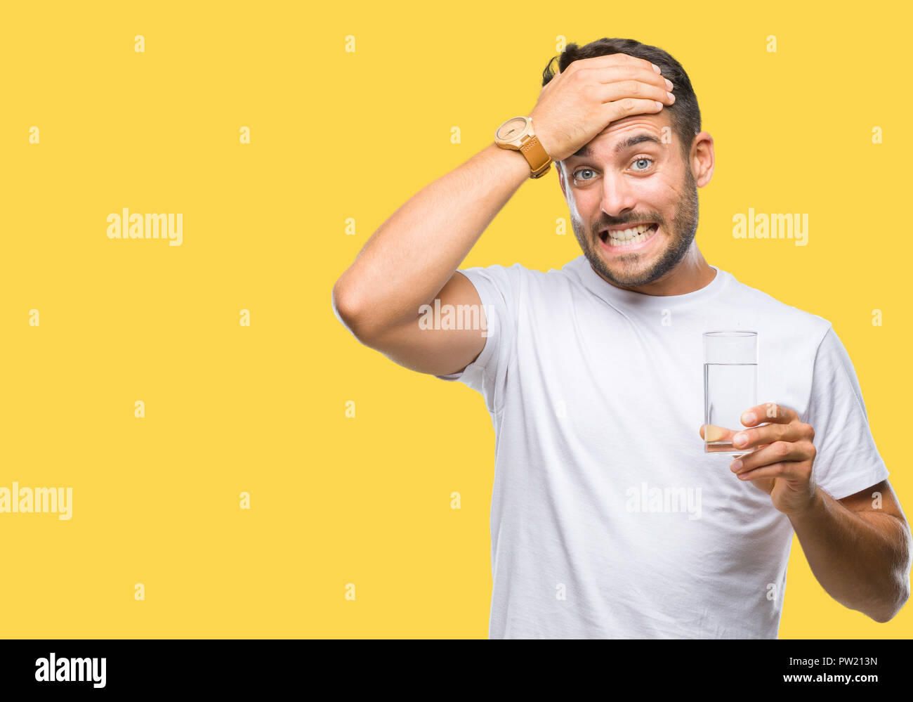Young handsome man drinking glass of water over isolated background ...