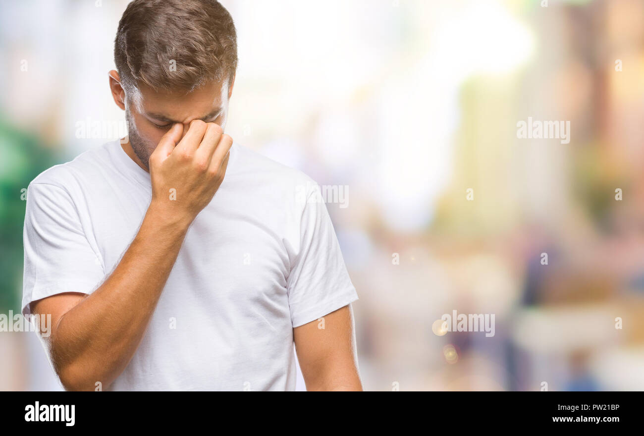 Young handsome man over isolated background tired rubbing nose and eyes ...