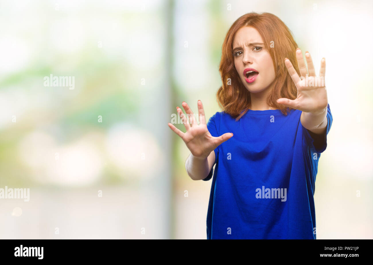 Young beautiful woman over isolated background afraid and terrified ...