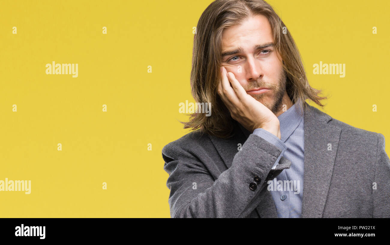 Young handsome business man with long hair over isolated background ...
