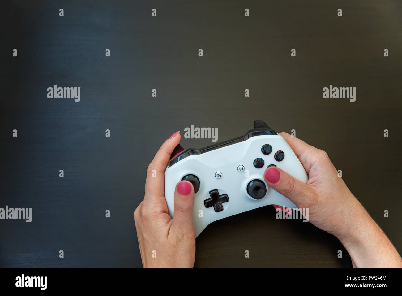 Woman hand holding white joystick gamepad, game console on black ...