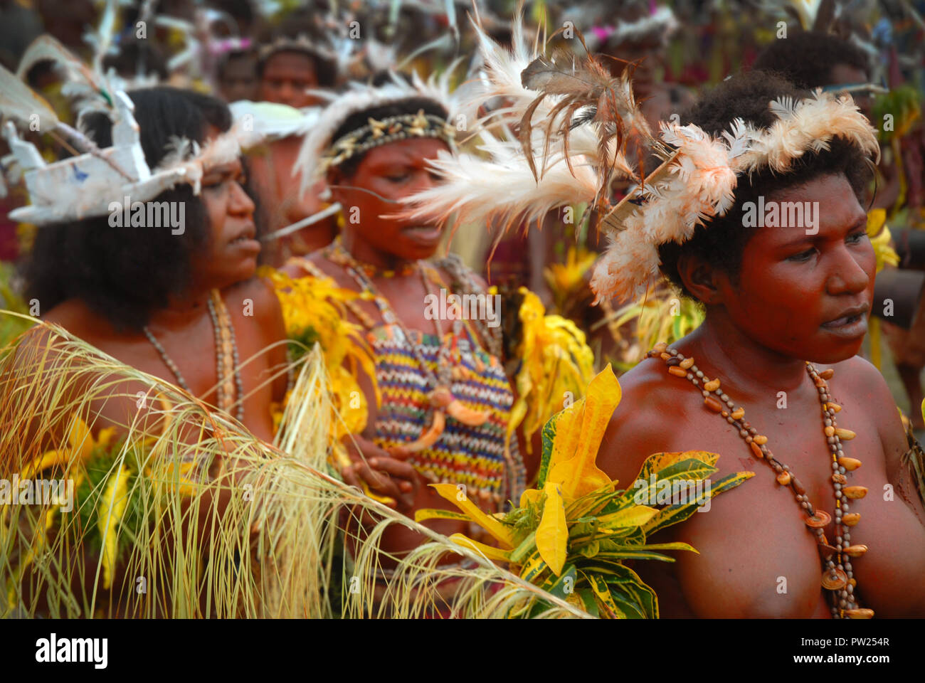 Colourfully dressed and face painted women dancing as part of a Sing ...