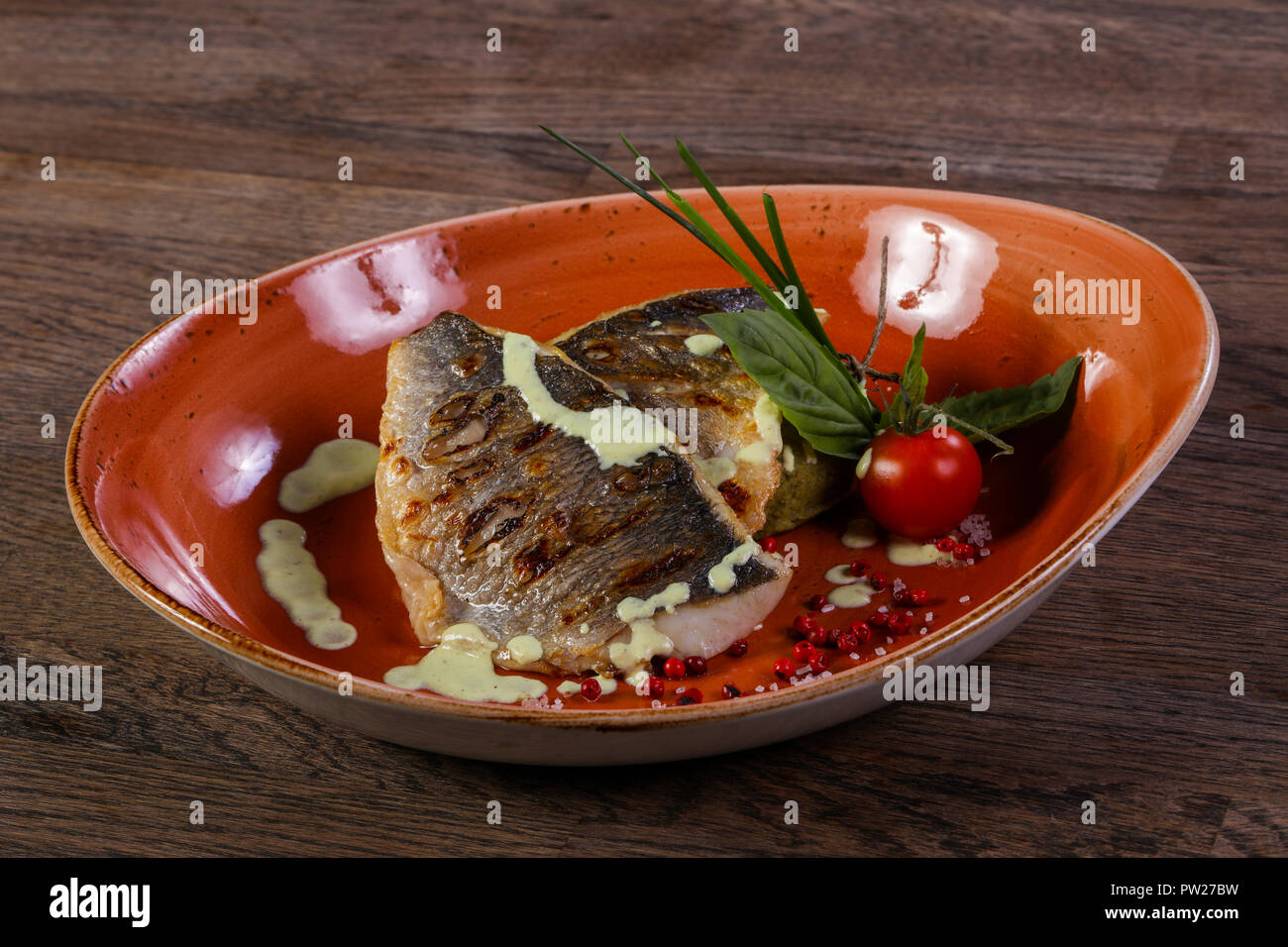 Grilled dorada fillet served tomato and onion Stock Photo - Alamy
