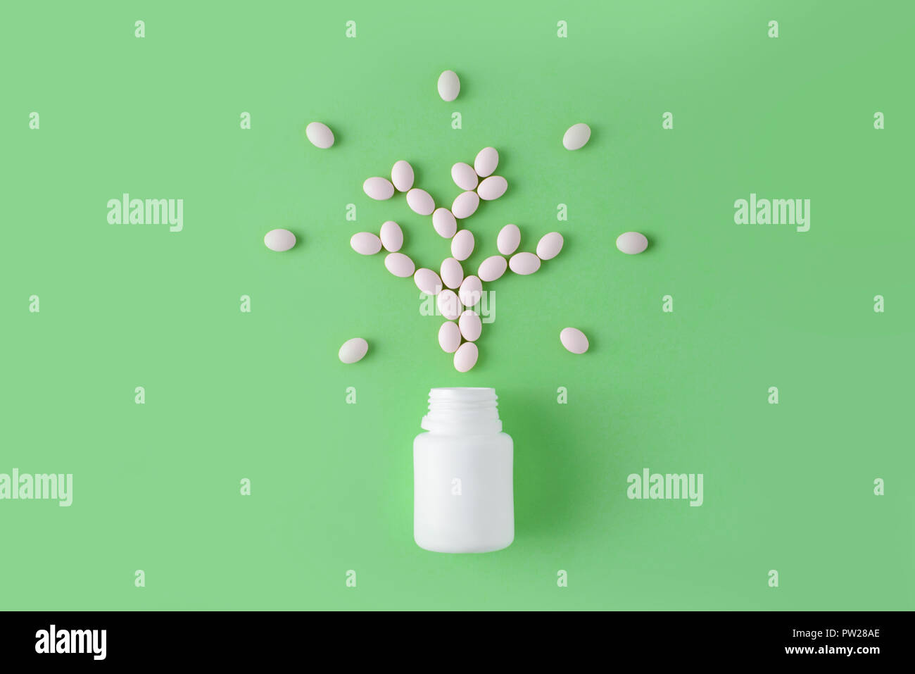 White pills in shape of tree on green background. Natural medical ...