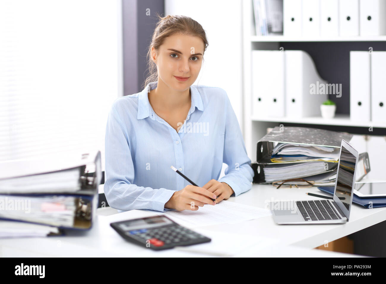 Woman bookkeeper or financial inspector calculating or checking balance ...