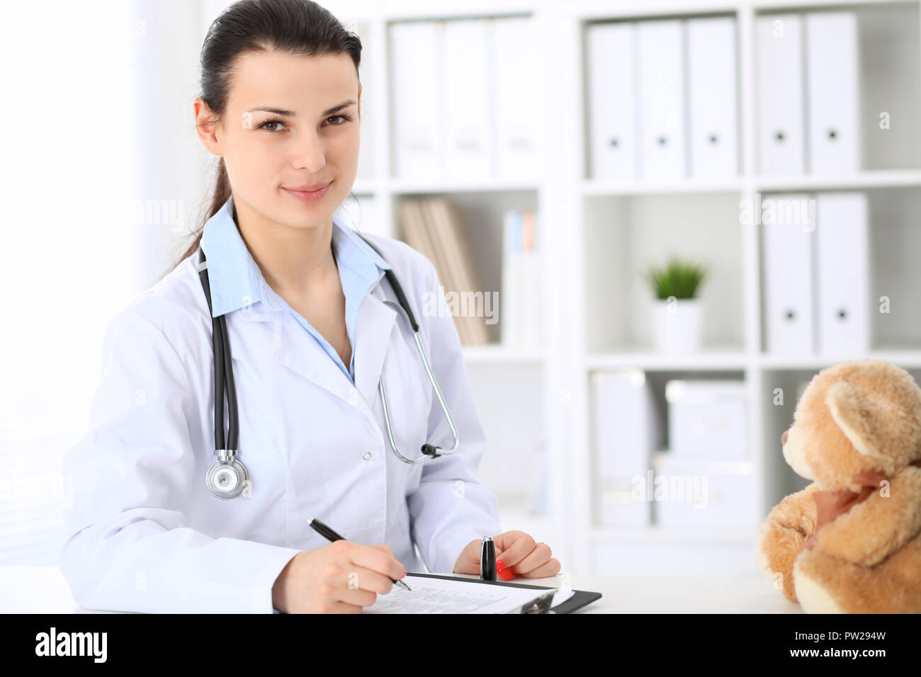 Young brunette female doctor at working place in hospital. Health care ...
