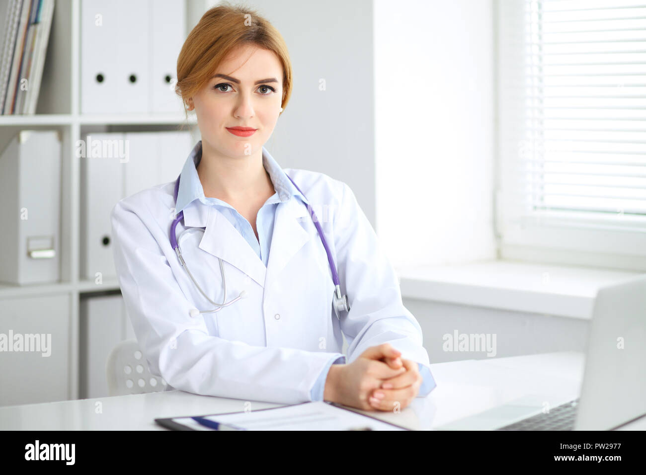 Female doctor sitting at the desk near window. Medicine and health care ...
