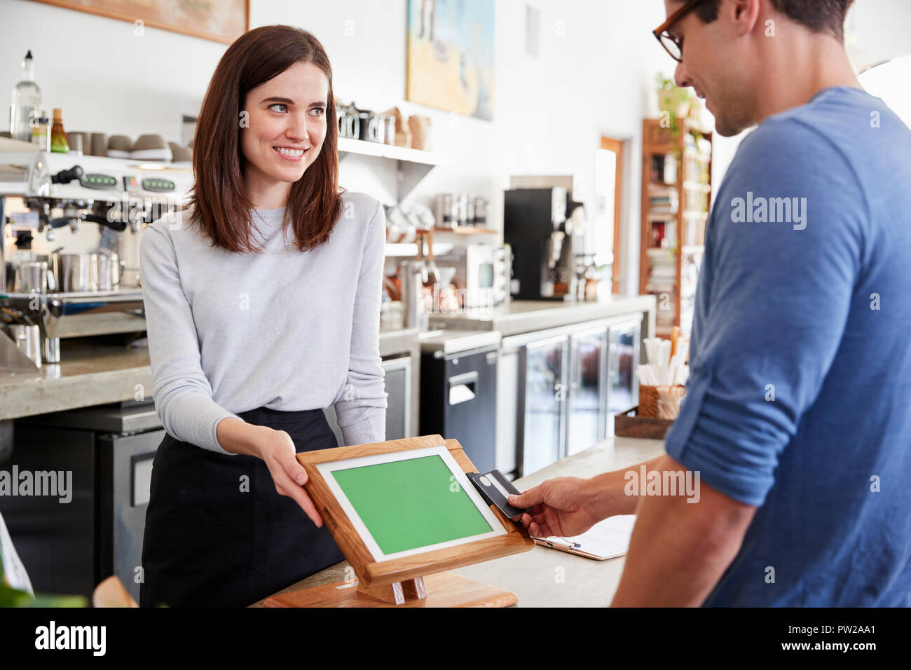 Male customer makes contactless card payment at coffee shop Stock Photo ...