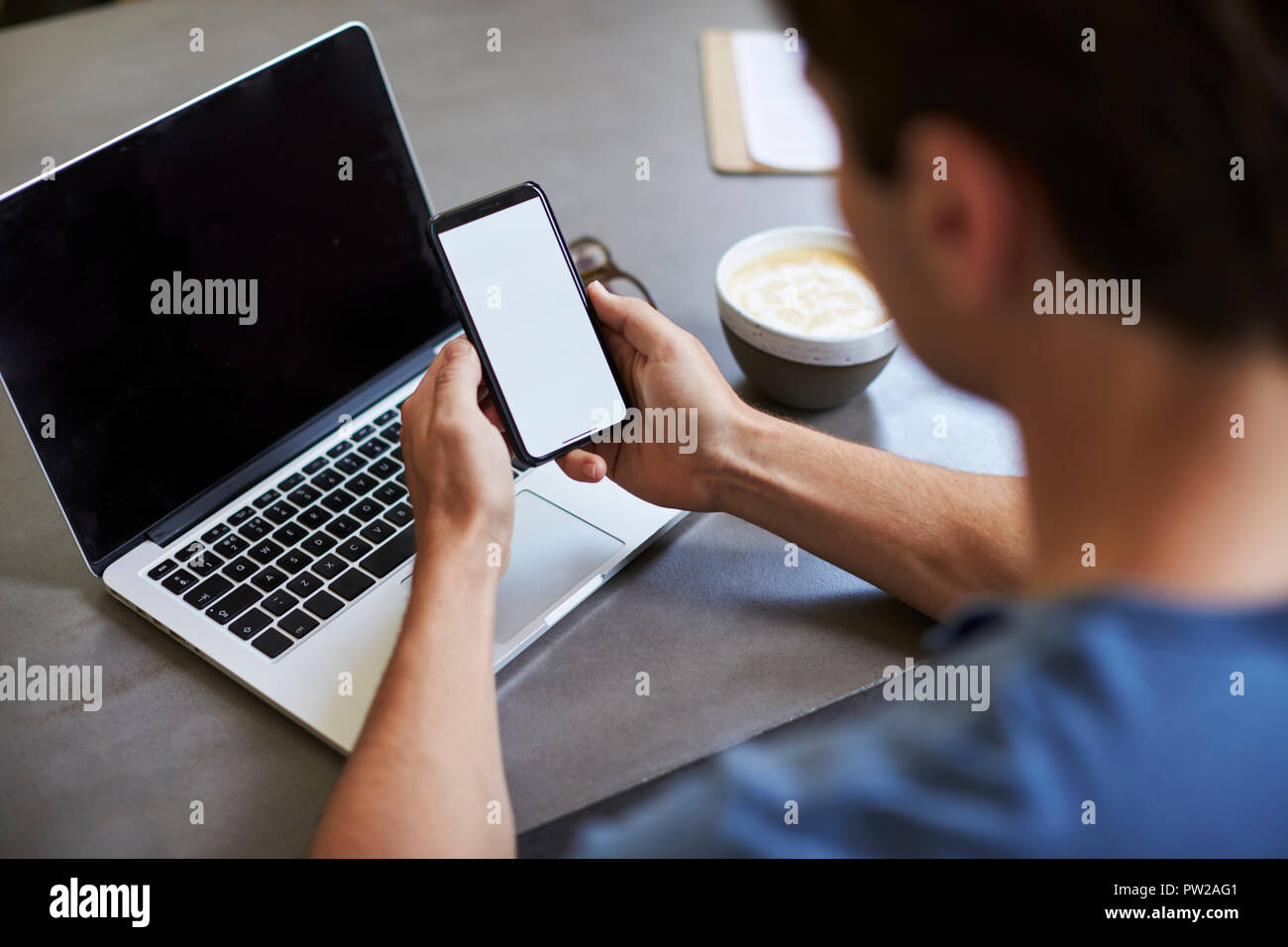Young man using smartphone in a coffee shop, back view Stock Photo - Alamy