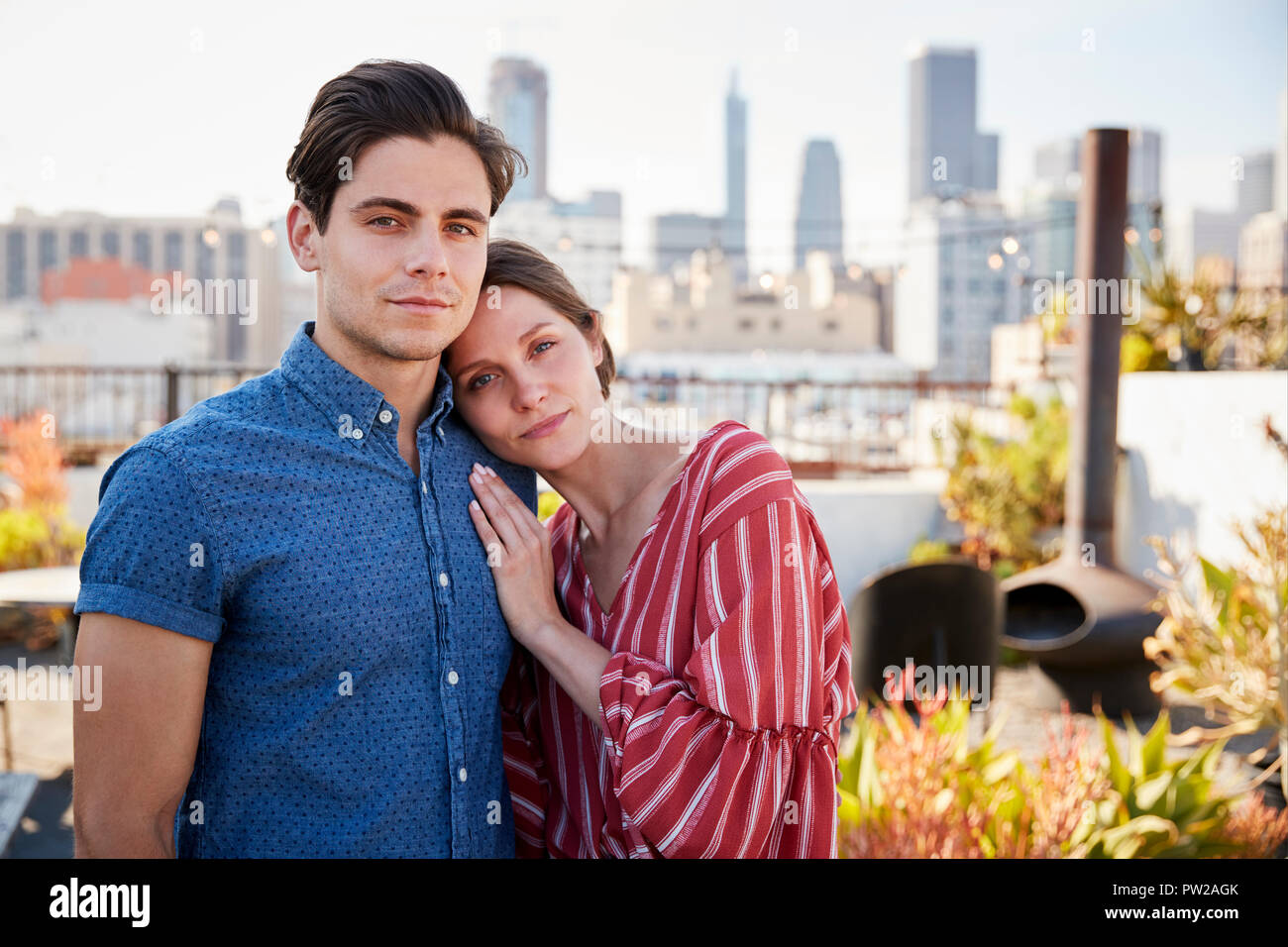 Portrait Of Romantic Couple On Rooftop Terrace With City Skyline In ...