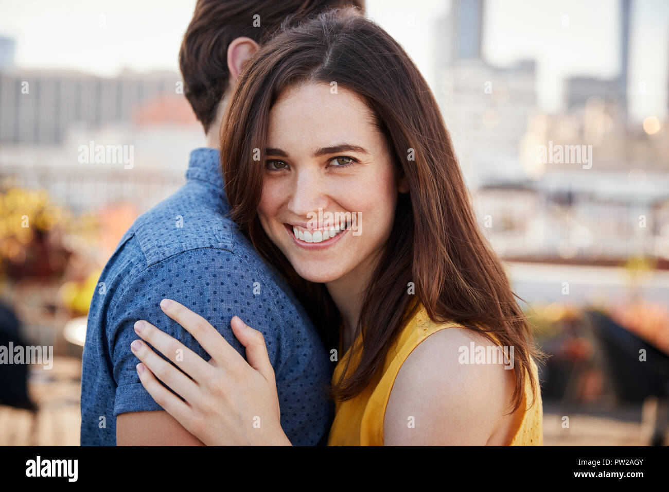 Portrait Of Romantic Couple On Rooftop Terrace With City Skyline In ...