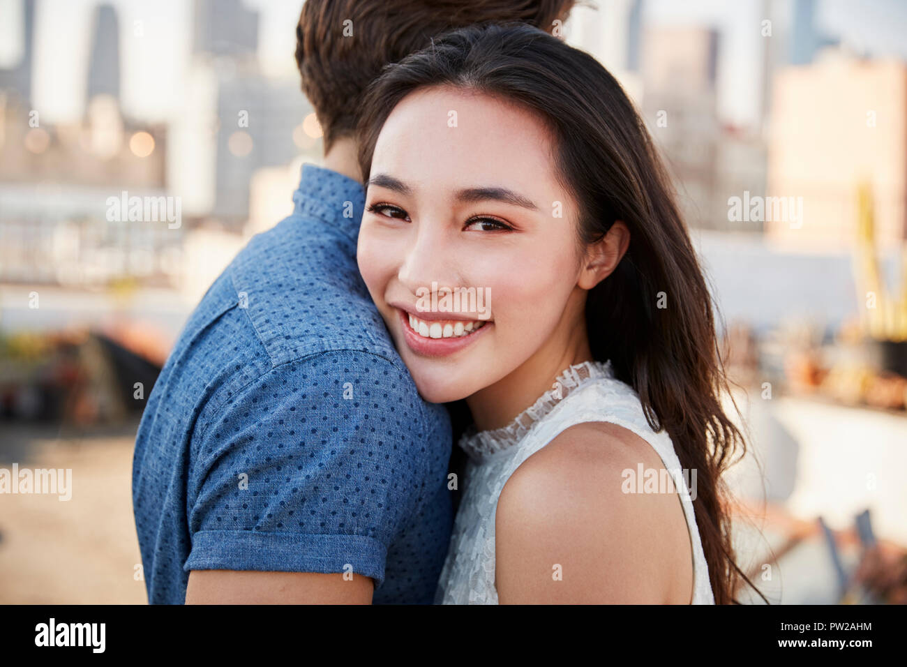 Portrait Of Romantic Couple On Rooftop Terrace With City Skyline In ...