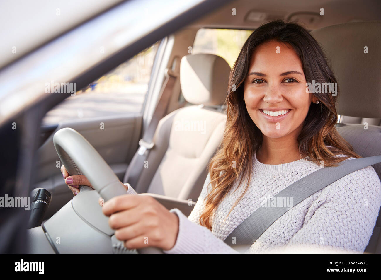 Young woman in car driving seat looking to camera, portrait Stock Photo ...