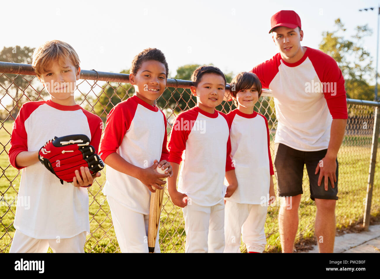 Coach and young boys in a baseball team looking to camera Stock Photo ...