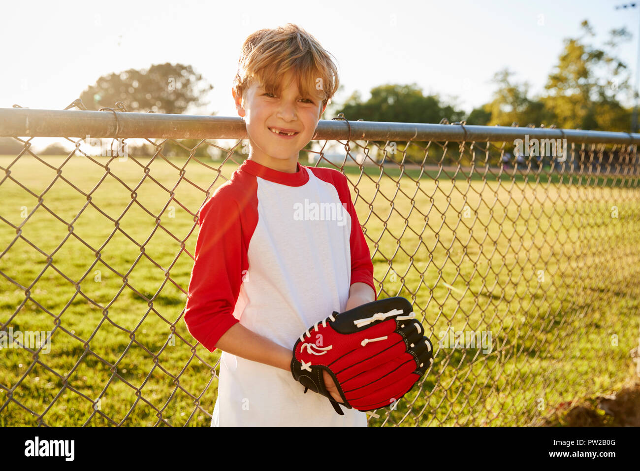A boy holding baseball mitt and smiling to camera Stock Photo - Alamy