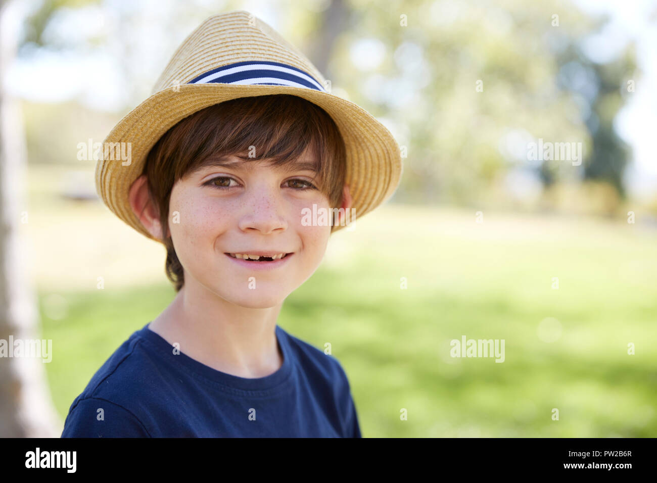 Young schoolboy in a sun hat smiling to camera, portrait Stock Photo ...