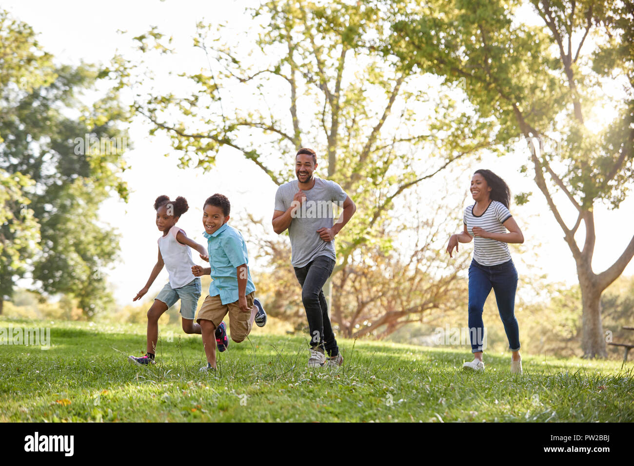 Family Running Through Park Together Stock Photo - Alamy