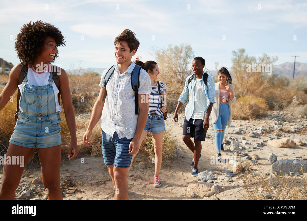 Group Of Young Friends Hiking Through Desert Countryside Together Stock ...