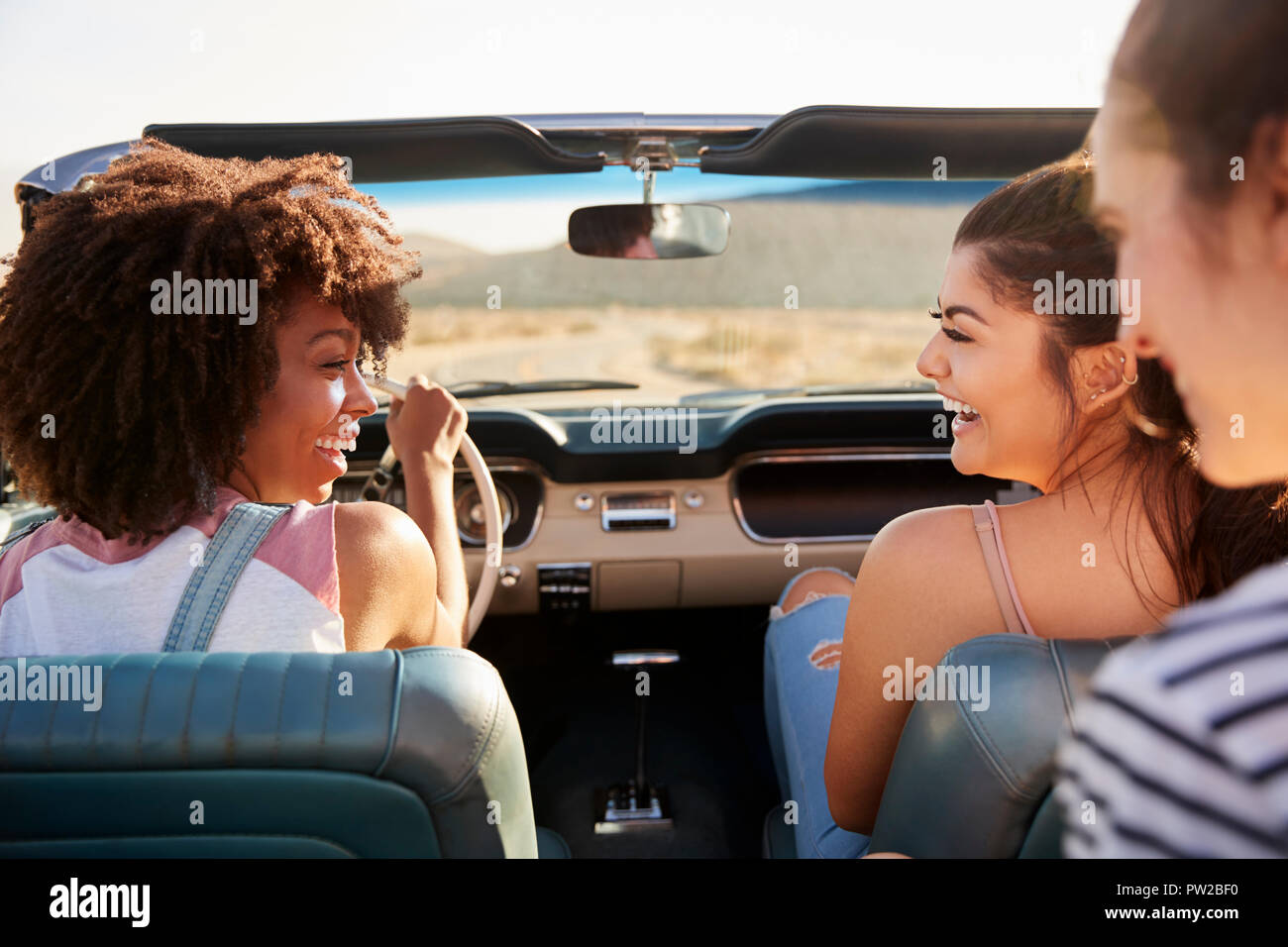 Three Female Friends Enjoying Road Trip In Open Top Classic Car Stock ...