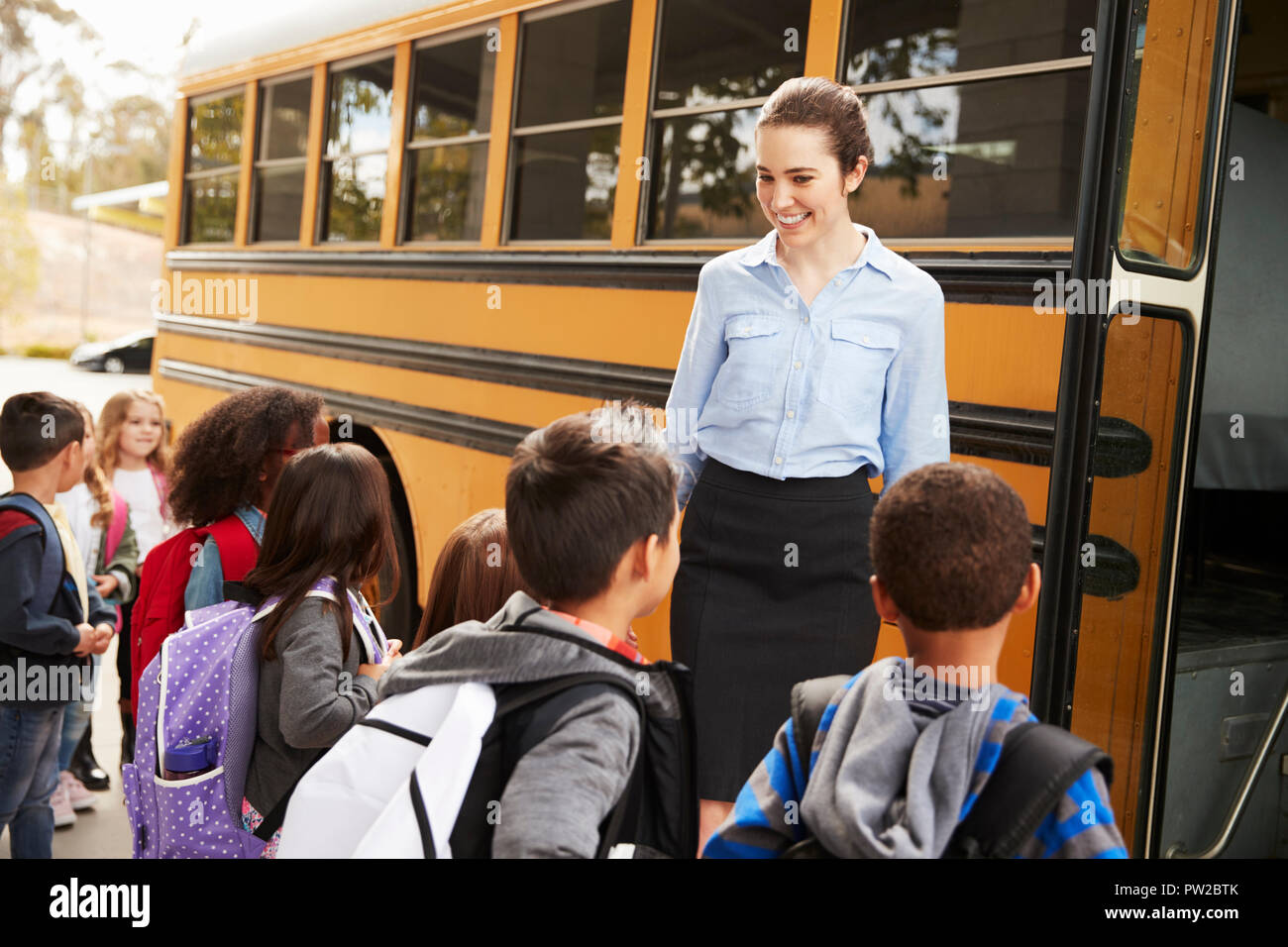 School teacher preparing kids to get on the school bus Stock Photo - Alamy