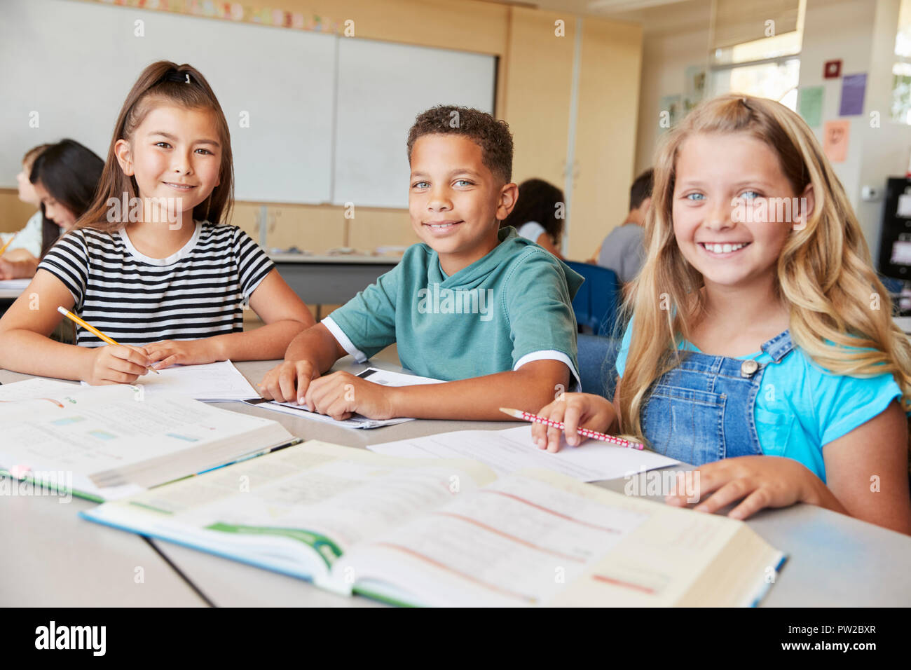 Elementary school kids in class smiling to camera, close up Stock Photo ...