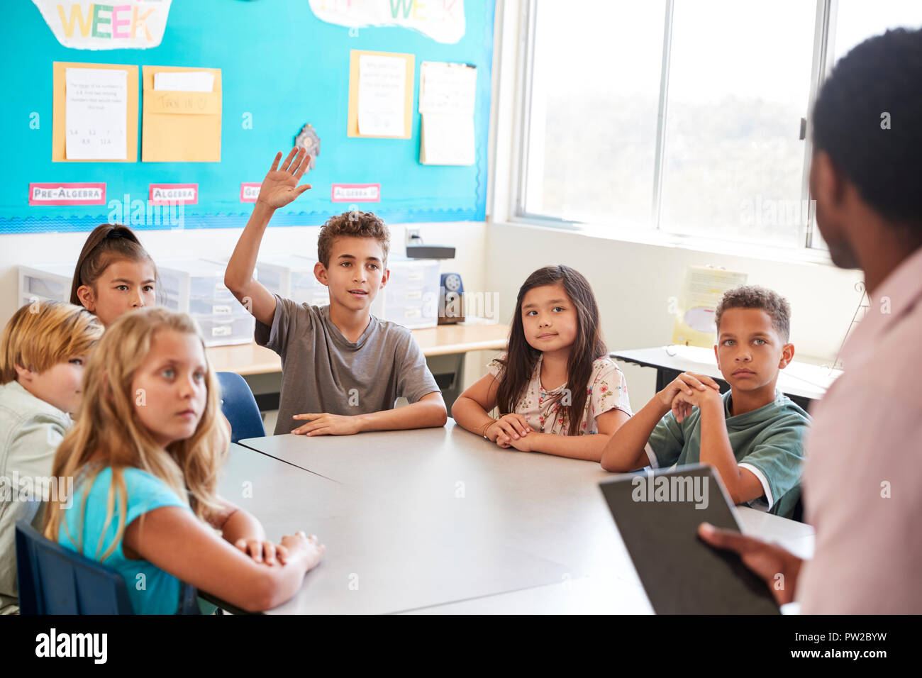 Schoolboy raising hand to answer in elementary school class Stock Photo ...