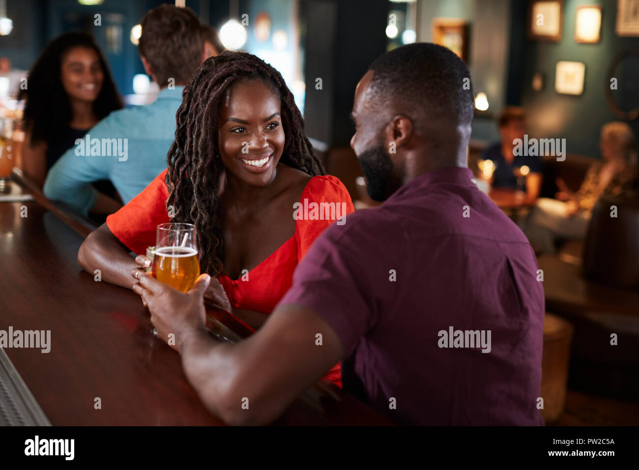 Couple On Date Sitting At Bar Counter And Talking Stock Photo - Alamy