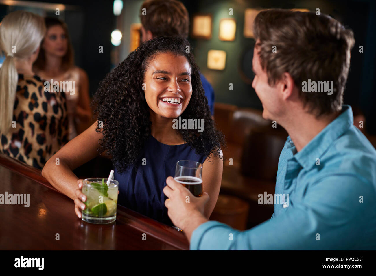 Couple On Date Sitting At Bar Counter And Talking Stock Photo - Alamy