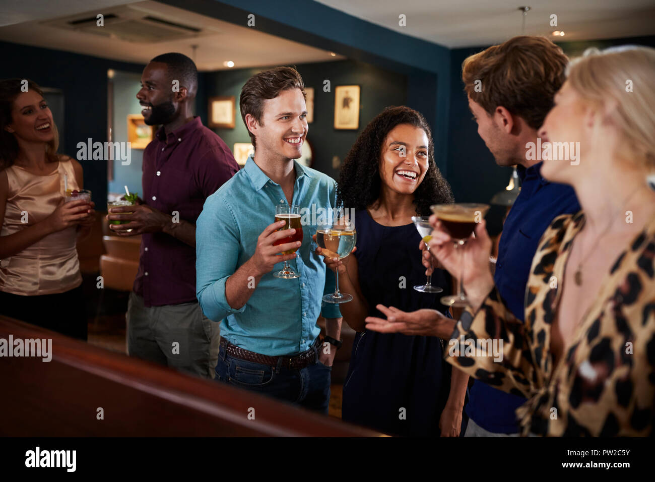 Group Of Young Friends Relaxing In Bar Together On Night Out Stock ...